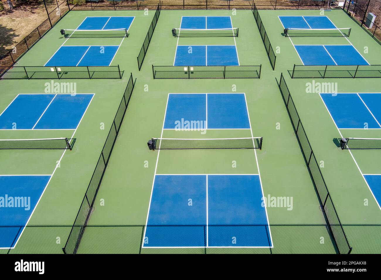 Aerial view of a pickleball complex with blue and green courts beside a ...