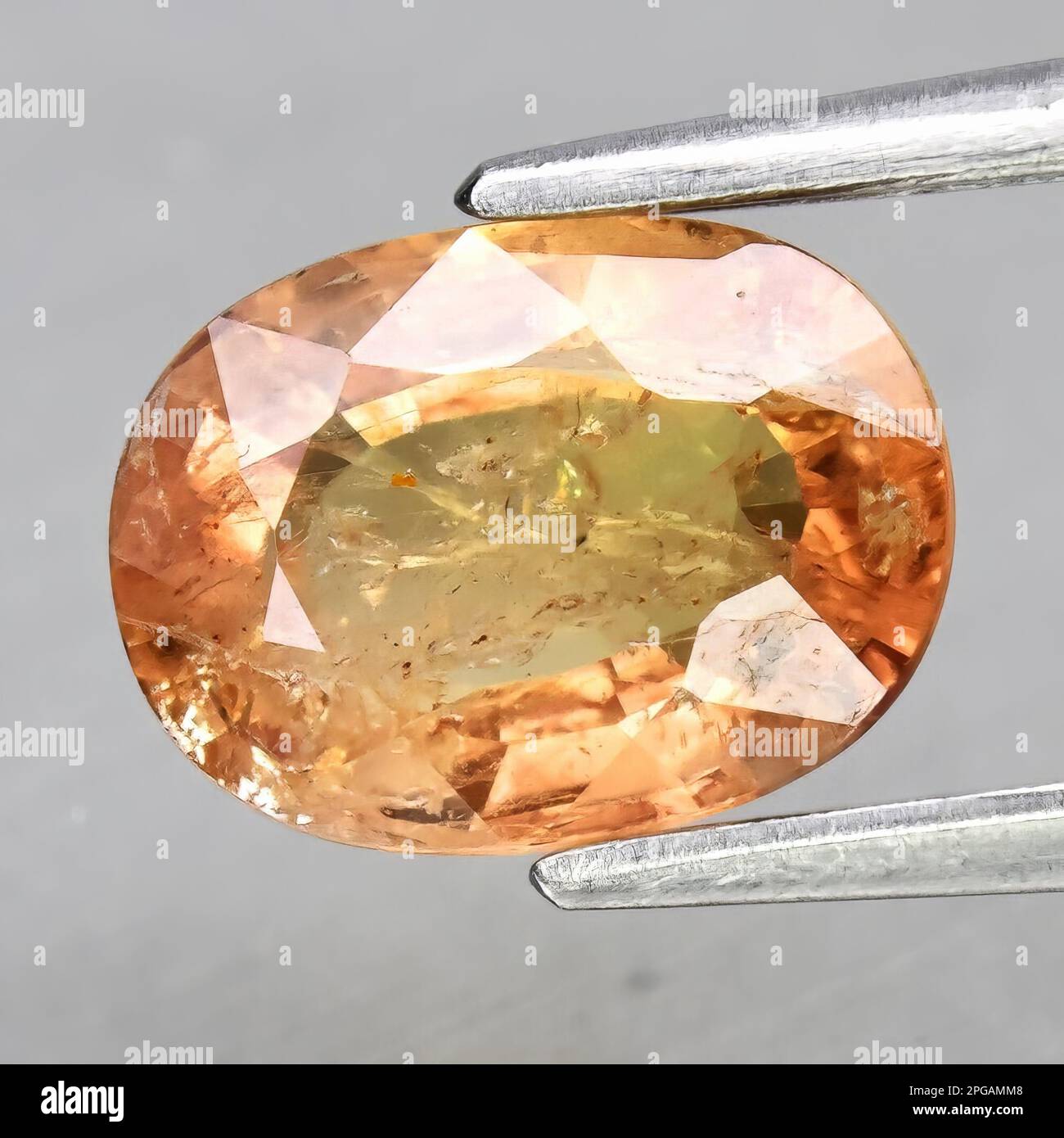 Natural gem orange Padparadscha sapphire on gray background Stock Photo ...