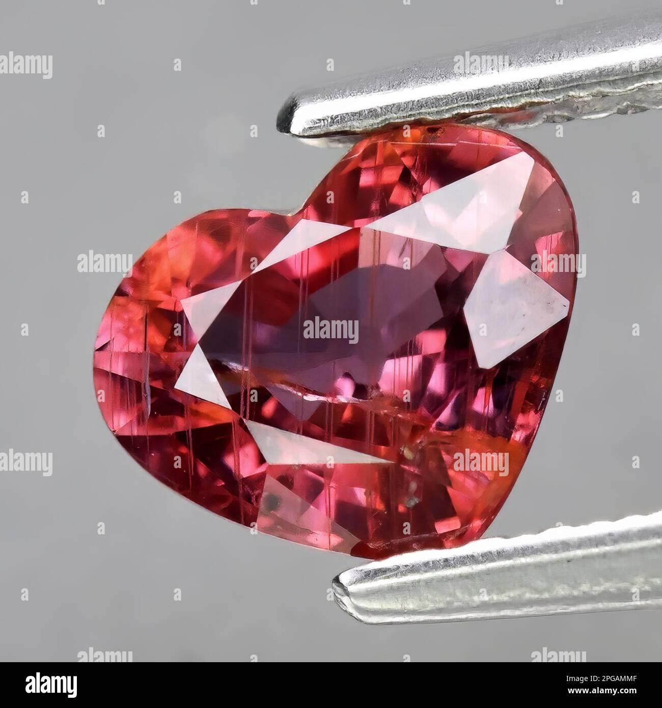 Natural gem orange Padparadscha sapphire on gray background Stock Photo ...