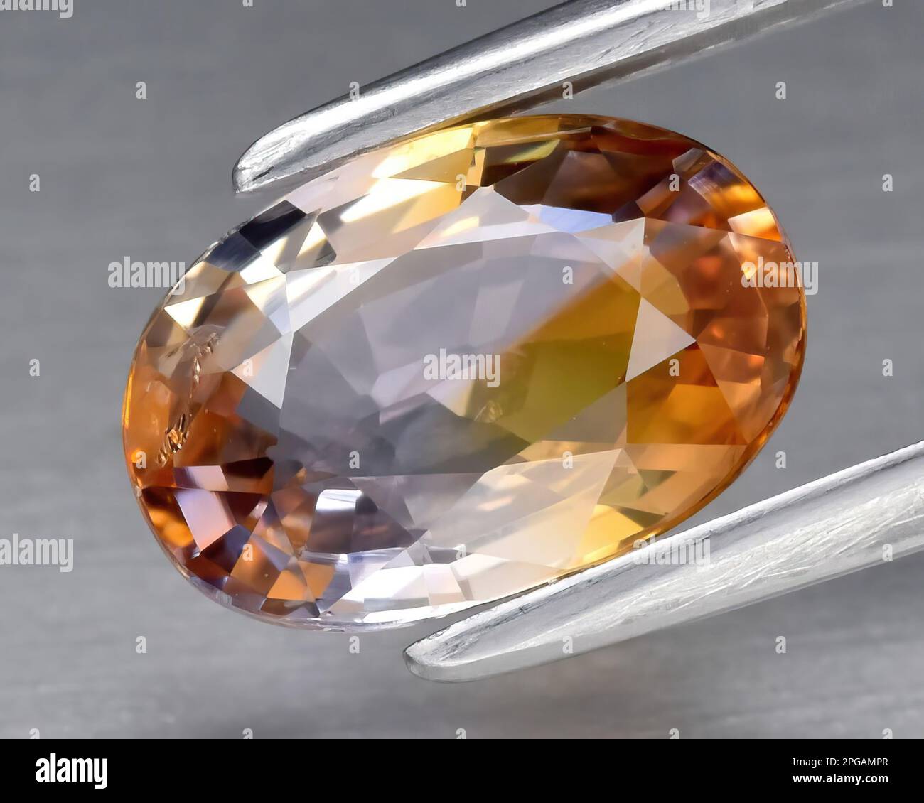 Natural gem orange Padparadscha sapphire on gray background Stock Photo ...