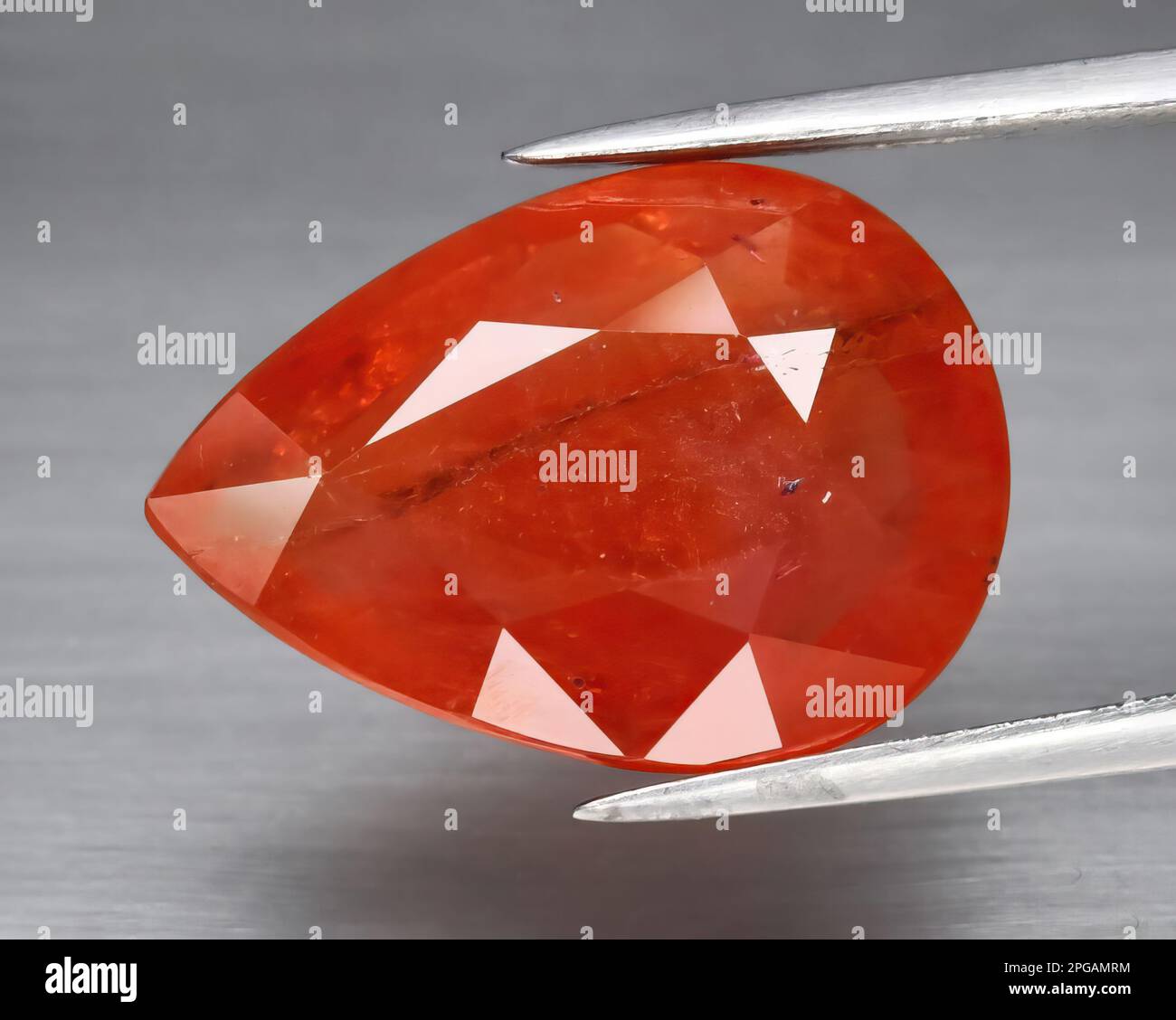 Natural gem orange Padparadscha sapphire on gray background Stock Photo ...