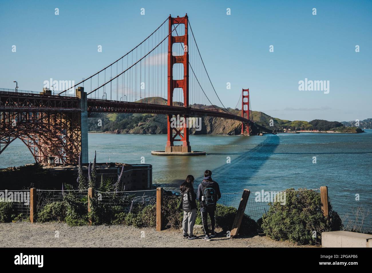 A couple takes a photo with the Golden Gate Bridge in the background ...