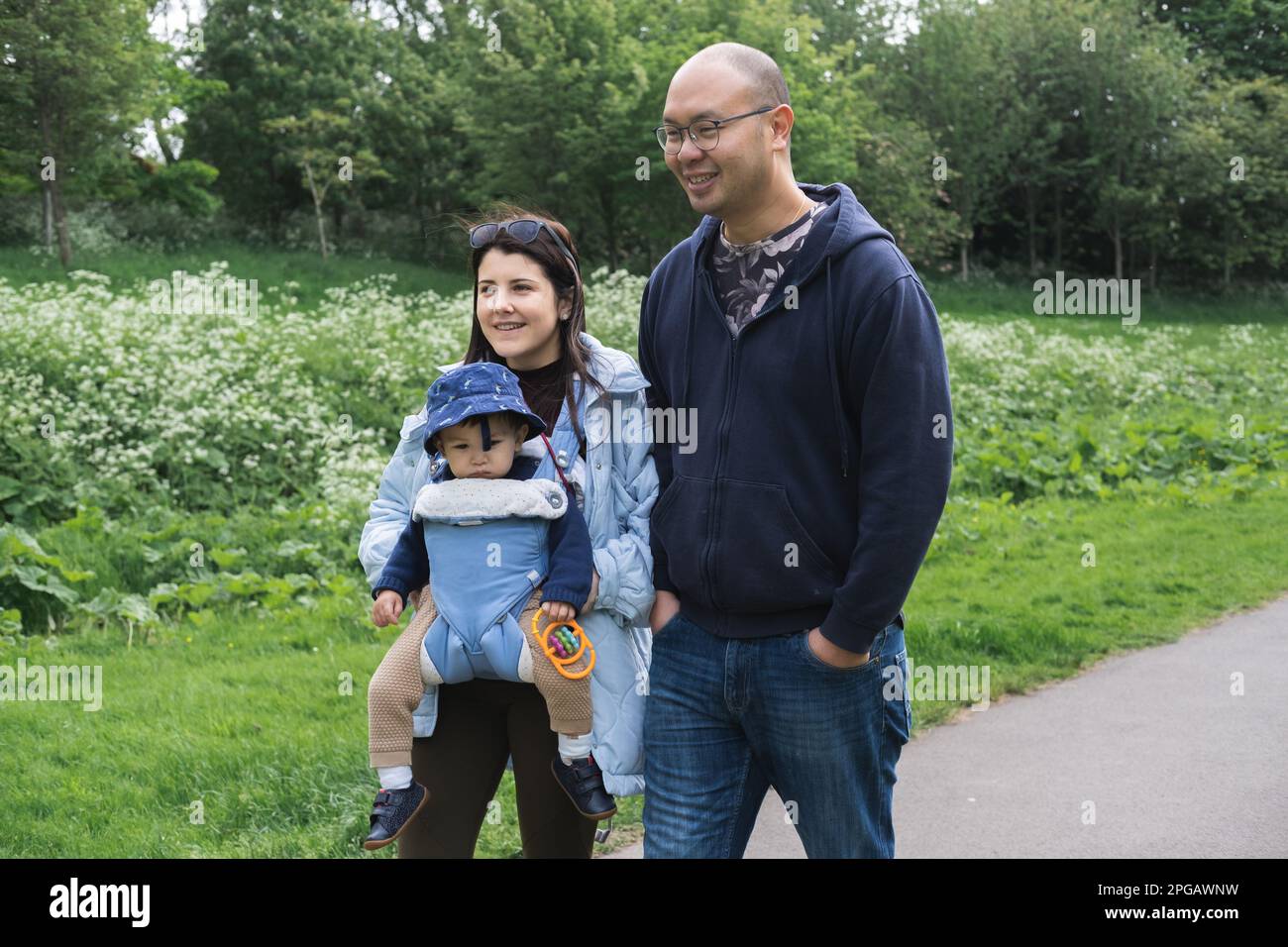 A smiley multicultural family walking on a footpath in Figgate Park in ...