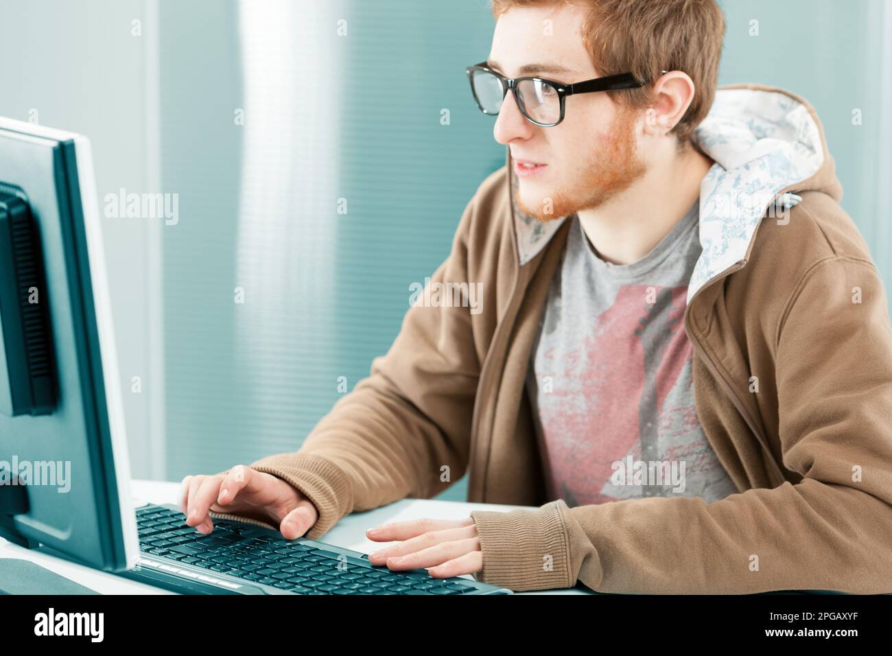 Young millennial worker in front of computer screen. Wearing black ...