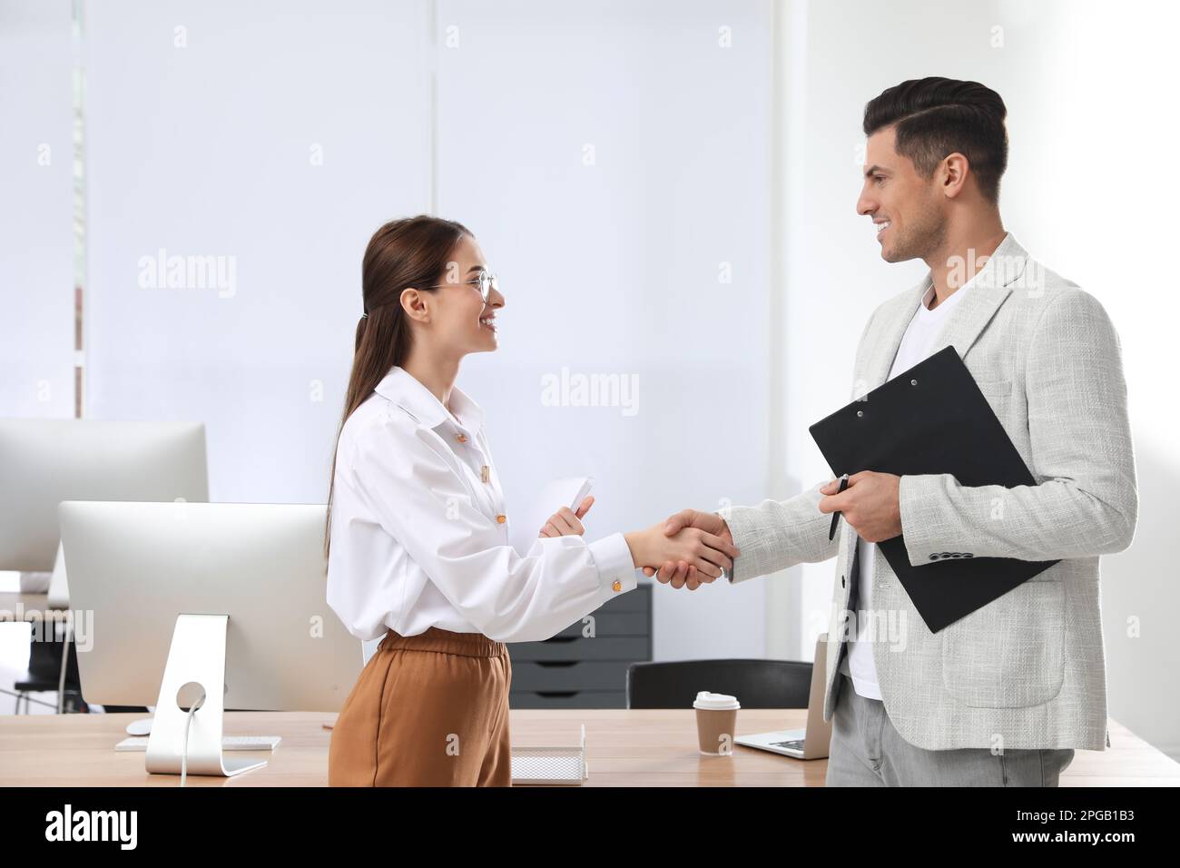 Employee shaking hands with intern in office Stock Photo - Alamy