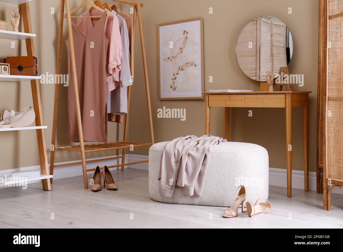 Stylish ottoman, console table and clothing rack in dressing room ...