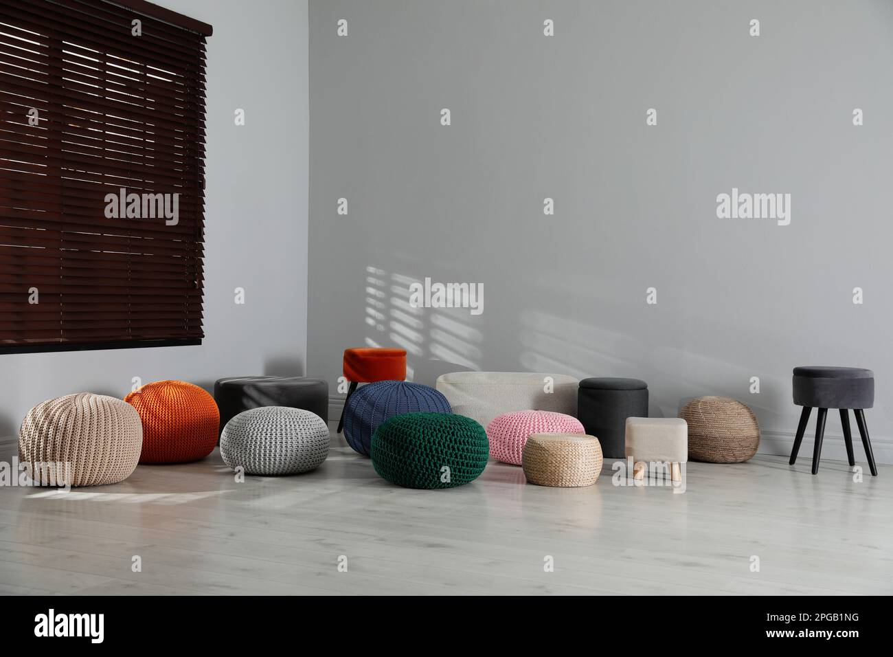 Many stylish different poufs in room. Home design Stock Photo - Alamy