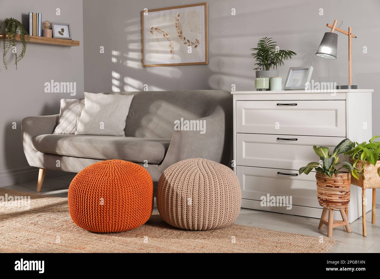 Stylish knitted poufs and sofa in living room. Home design Stock Photo ...
