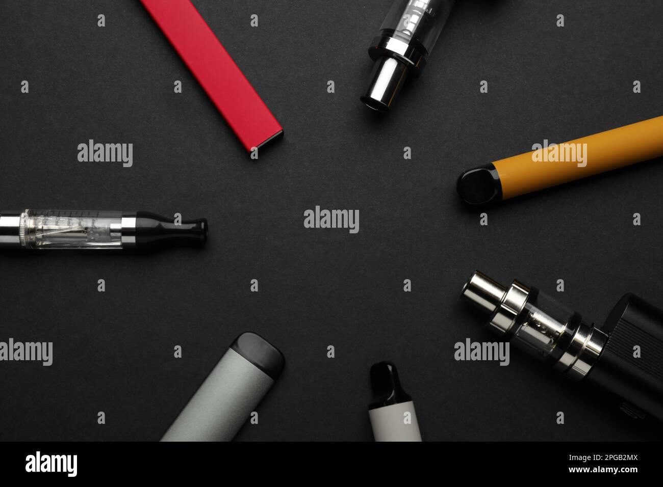 Many electronic smoking devices on black background, flat lay. Space ...
