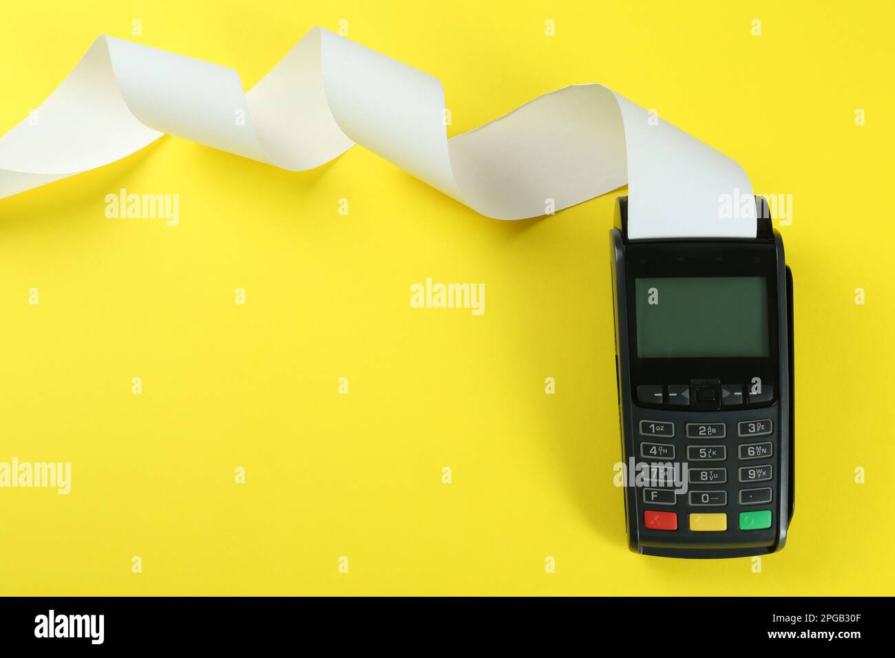 New modern payment terminal with blank paper bill on yellow background ...