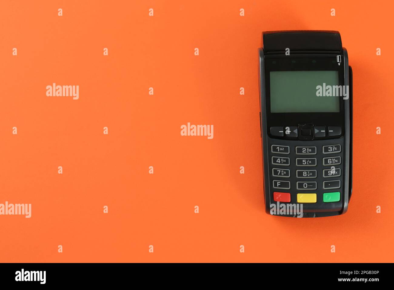 New modern payment terminal on orange background, top view. Space for ...