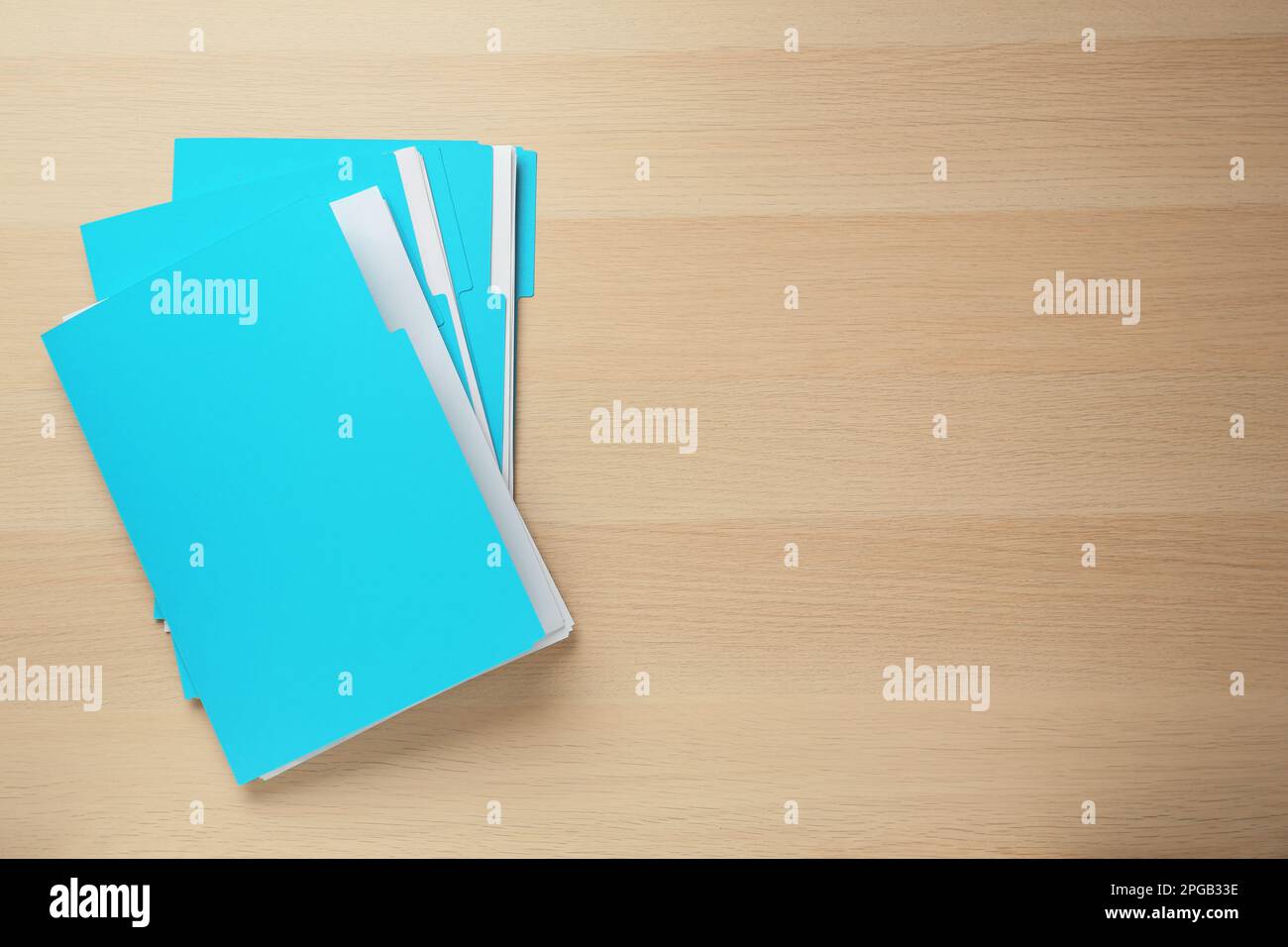 Turquoise files with documents on wooden table, top view. Space for ...