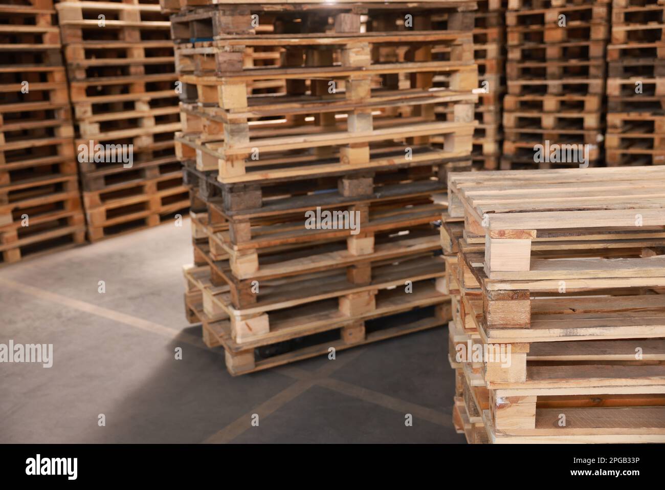 Many empty wooden pallets stacked in warehouse. Space for text Stock ...