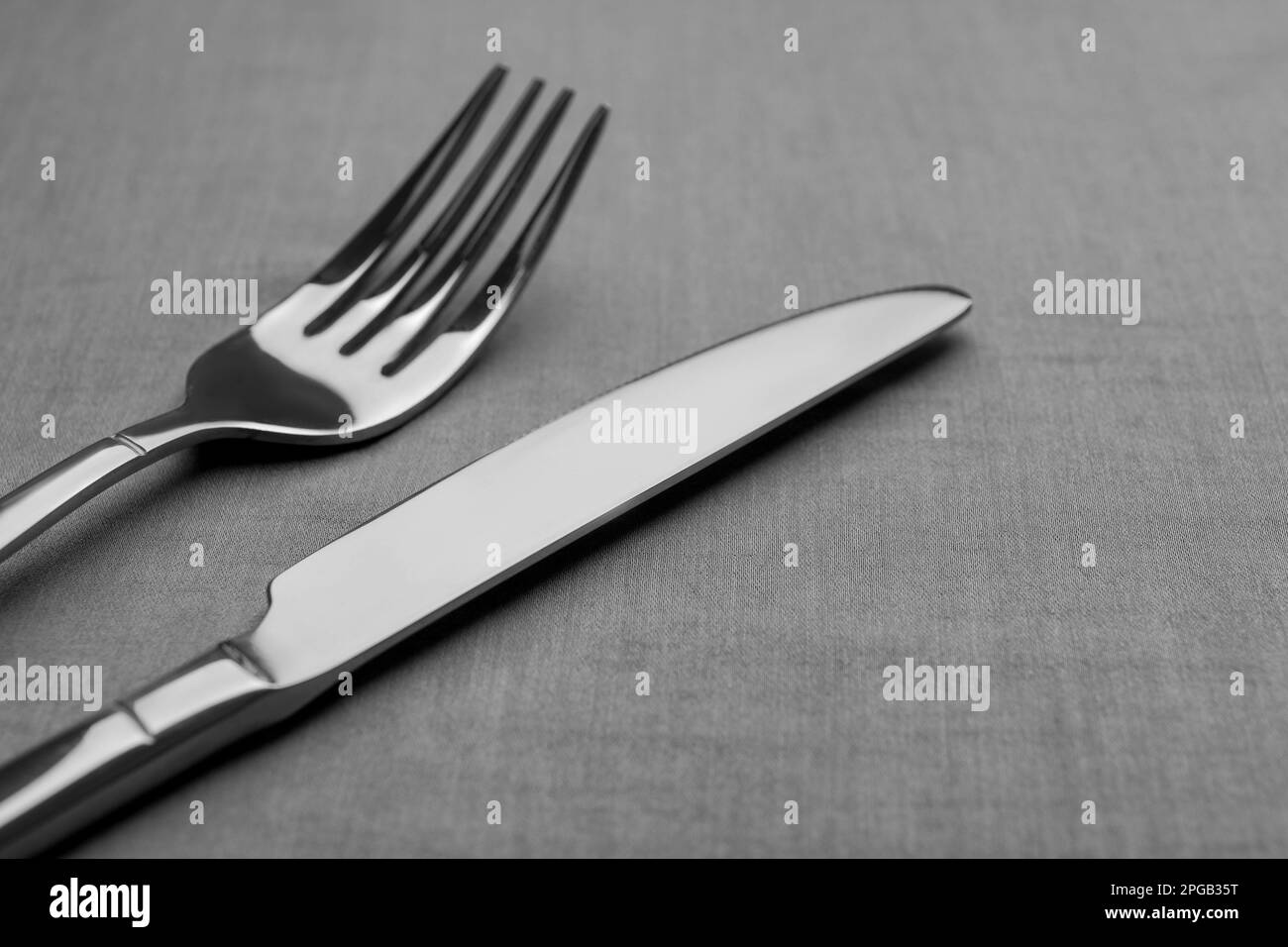 Shiny fork and knife on grey table, closeup Stock Photo - Alamy
