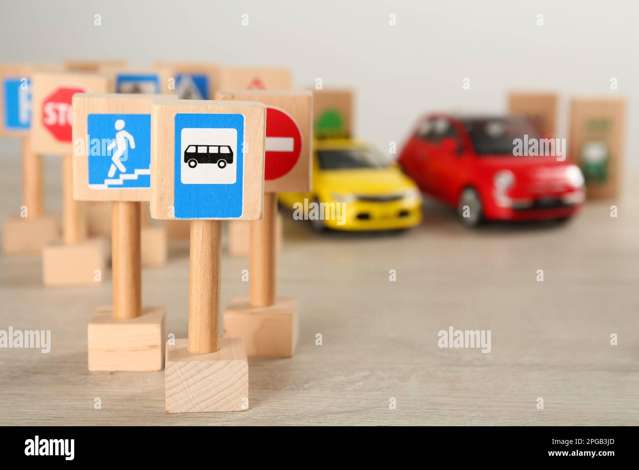 Many different miniature road signs and cars on wooden table, space for ...