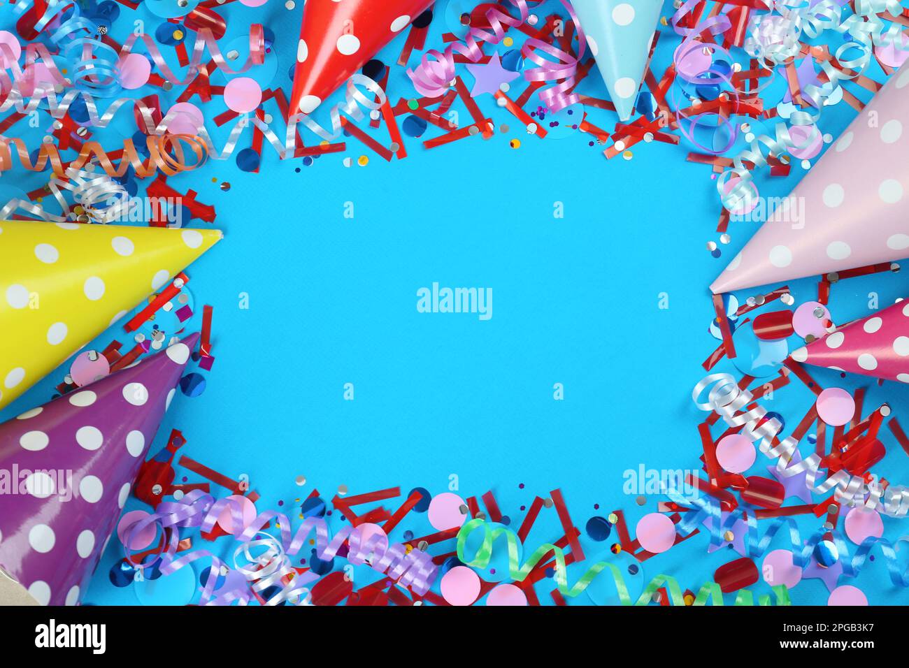 Frame of colorful serpentine streamers, party hats and confetti on ...