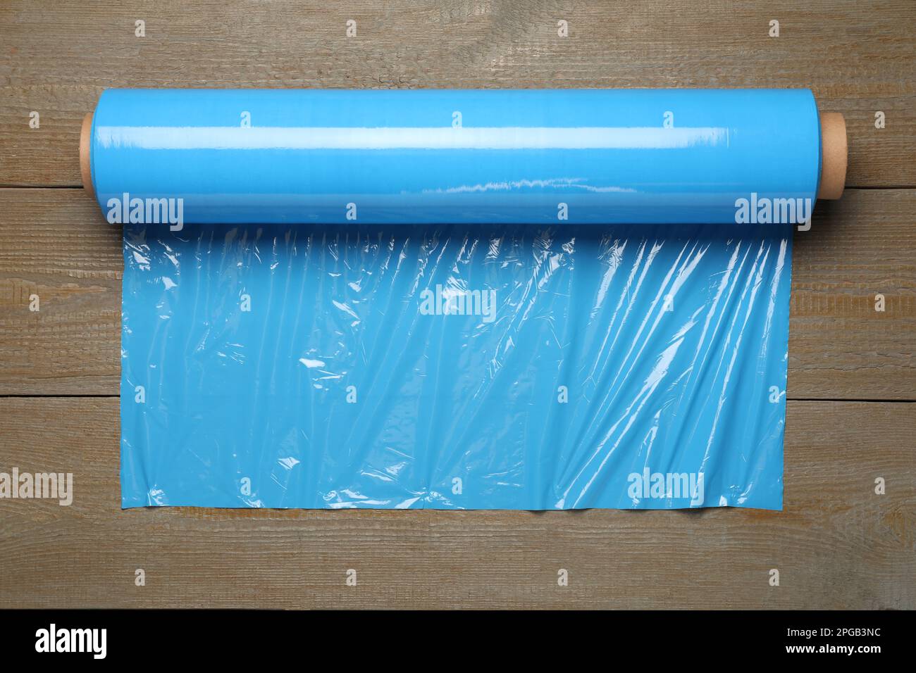Roll of plastic stretch wrap film on wooden table, top view Stock Photo ...