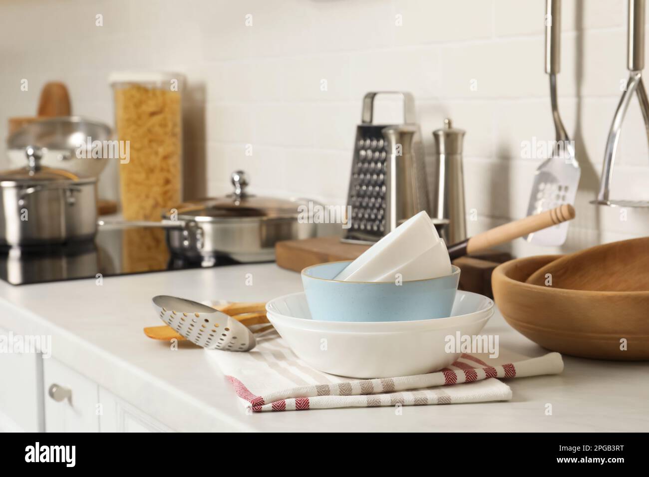 Stack of bowls and different cooking utensils on kitchen counter Stock ...