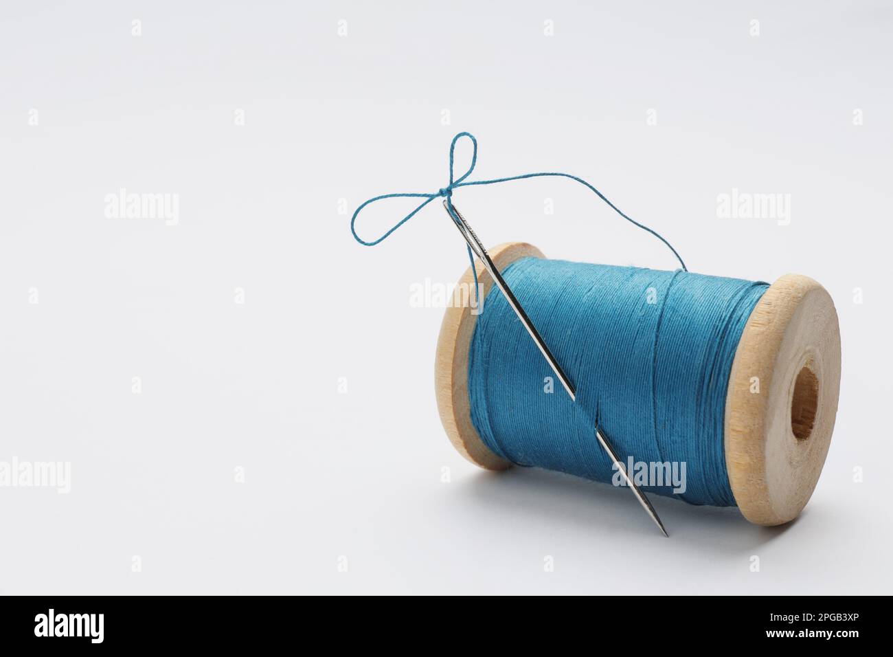 Light blue sewing thread with needle on white background Stock Photo ...