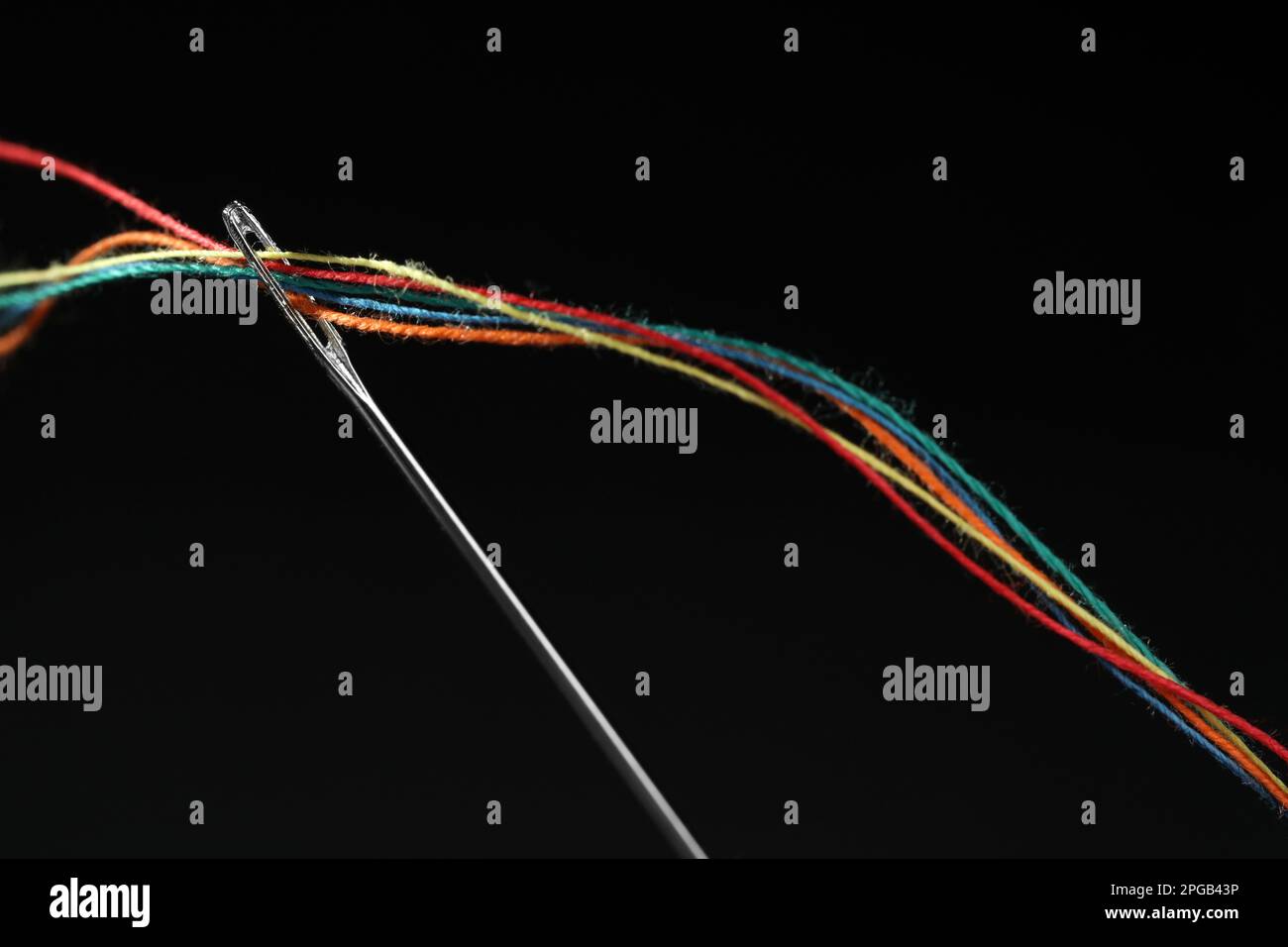 Sewing needle with colorful threads on black background, closeup Stock ...