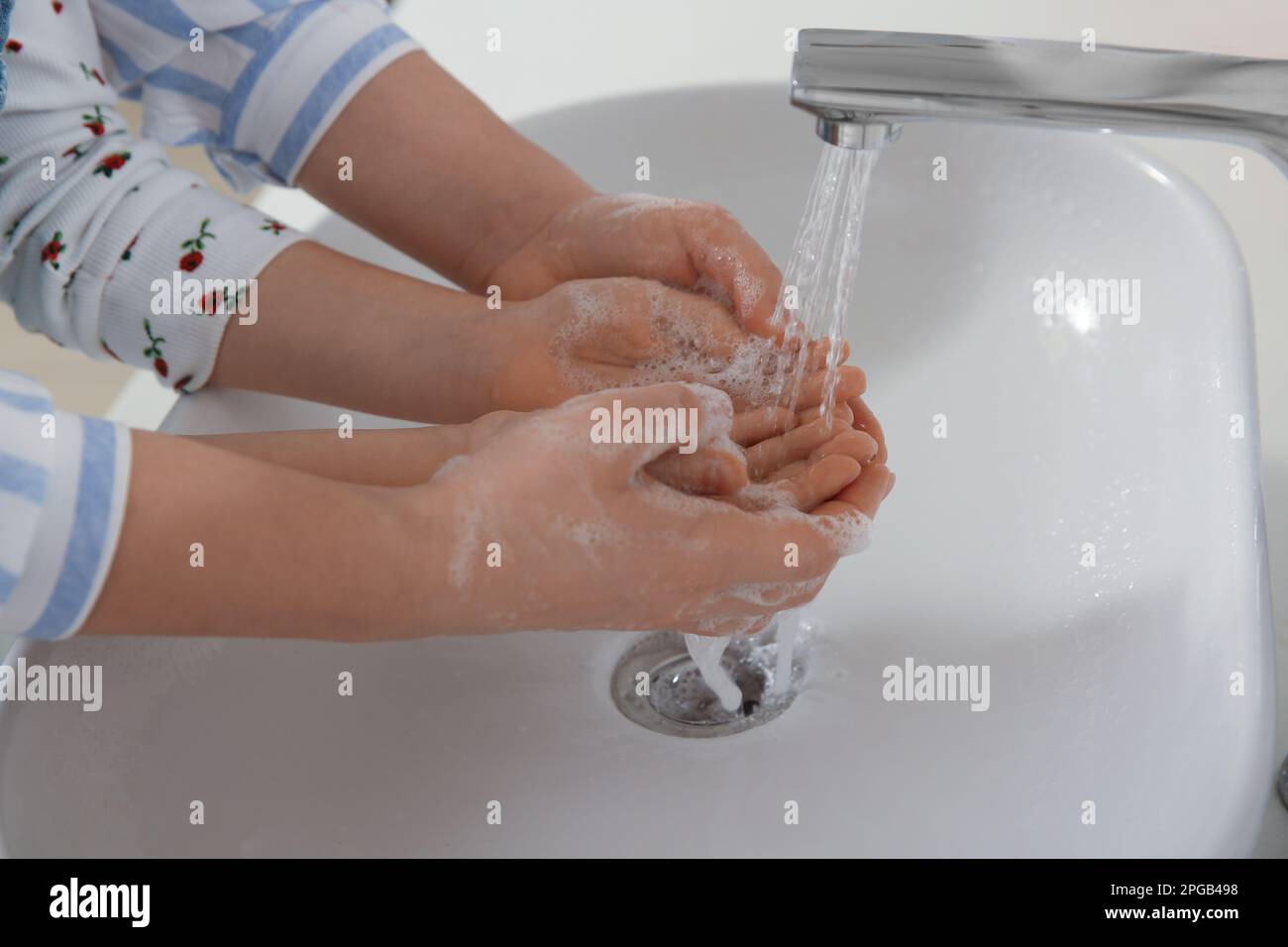 Mother and daughter washing hands with liquid soap together, closeup ...