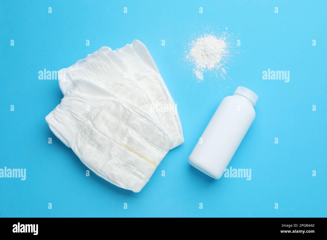 Dusting powder and diapers on light blue background, flat lay. Baby ...