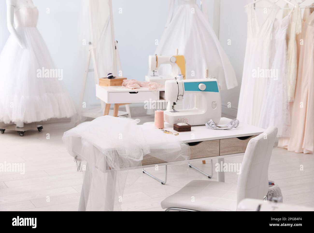 Dressmaking workshop interior with wedding dresses and equipment Stock ...
