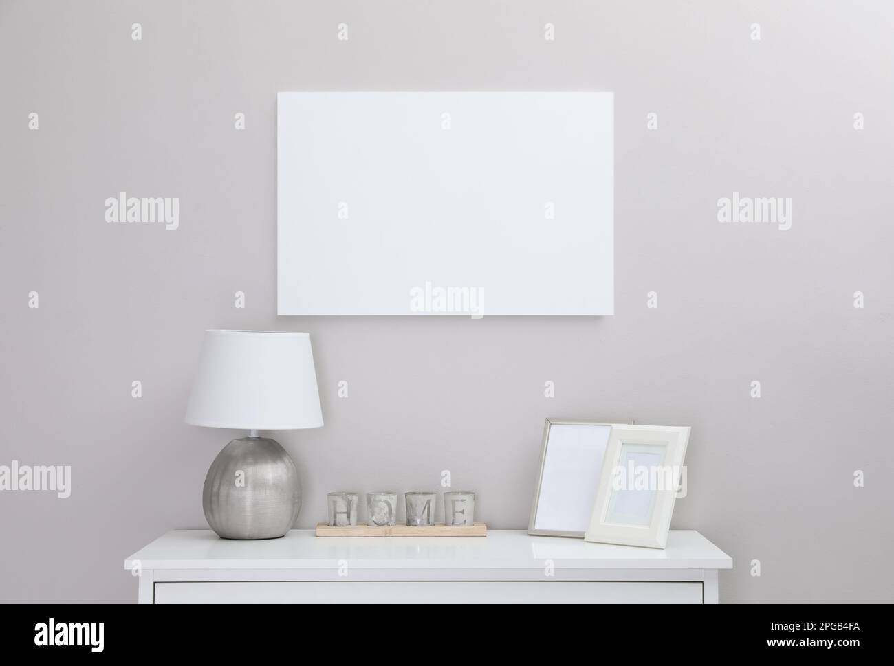 Blank canvas on wall over console table with decor indoors. Space for ...