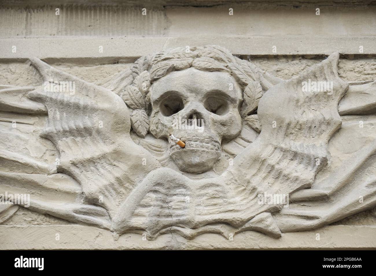 stone relief skull with cigarette. smoking kills concept Stock Photo ...