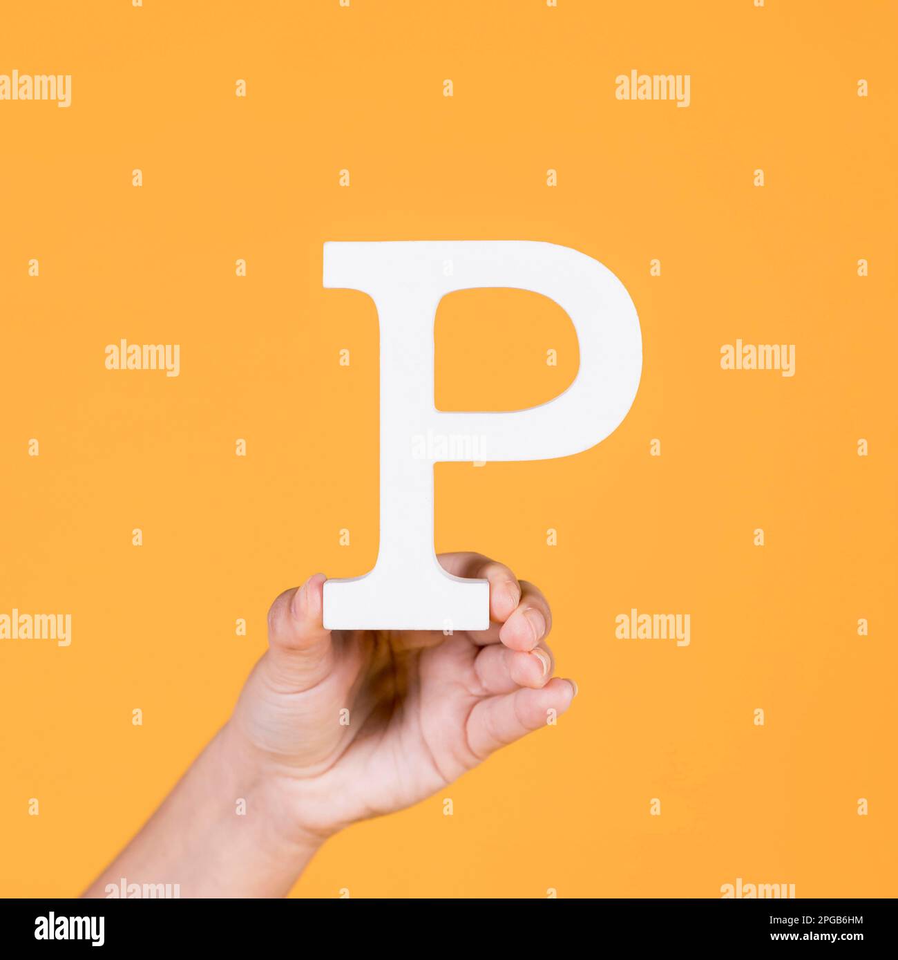 Woman s hand holding white letter p Stock Photo - Alamy