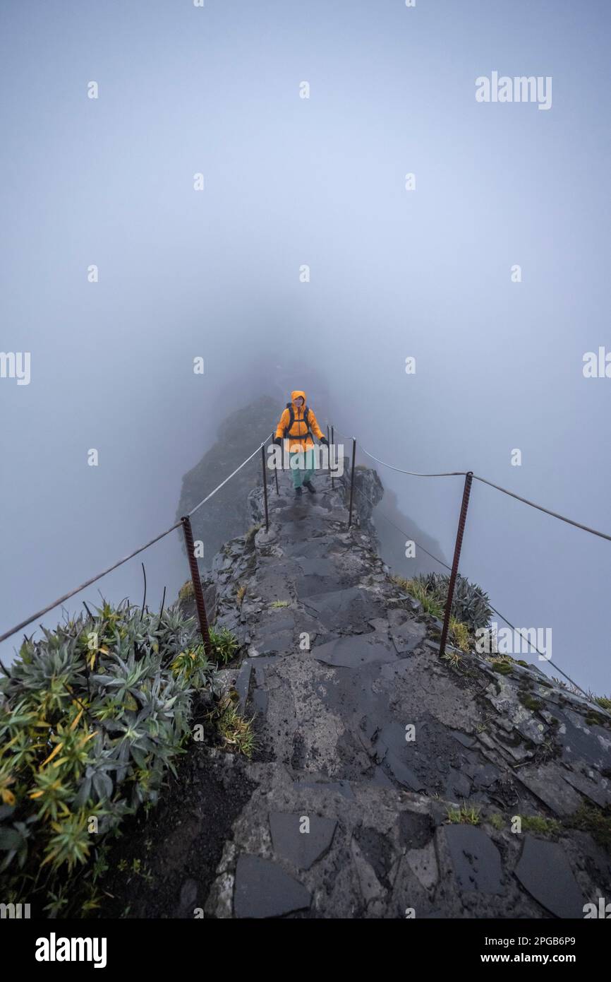 Hiker on a narrow slope in the fog, Pico Arieiro to Pico Ruivo hike ...