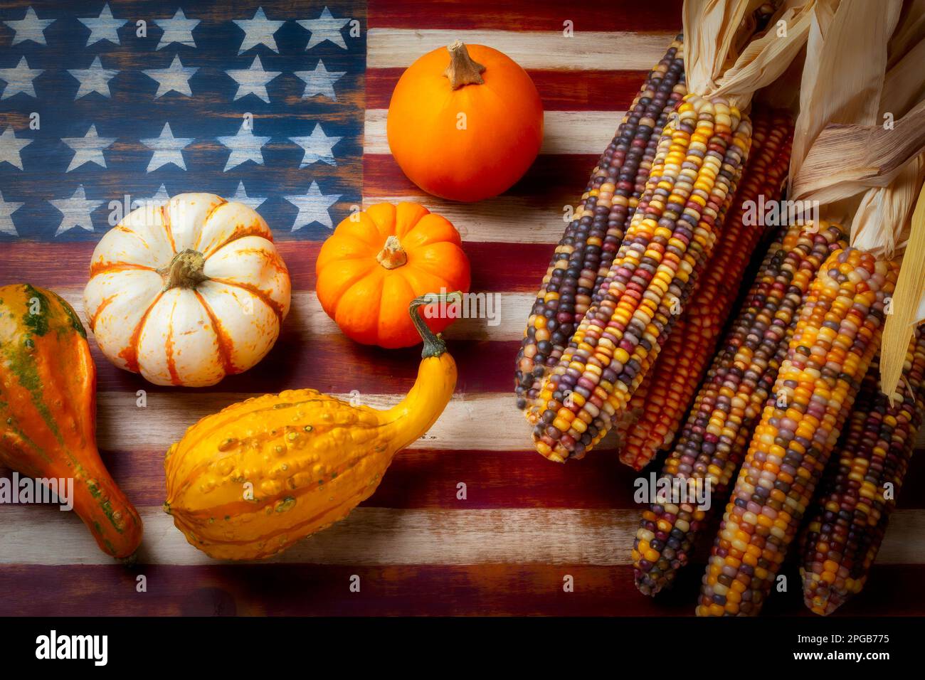 American Autumn, oumpkins and Indian corn on old wooden American fflag ...