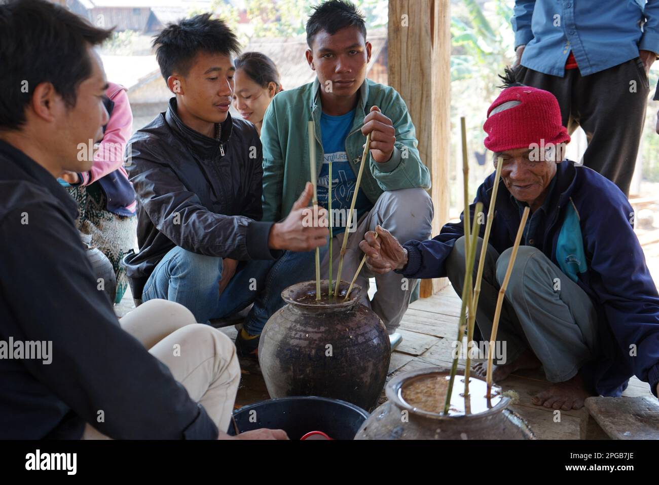 Members of the Khmu people drinking rice wine, stilt house, hill tribe ...