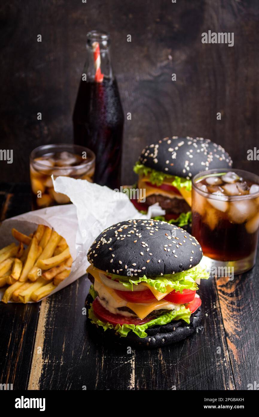 Set of black burgers with meat patty, cheese, tomatoes, mayonnaise ...