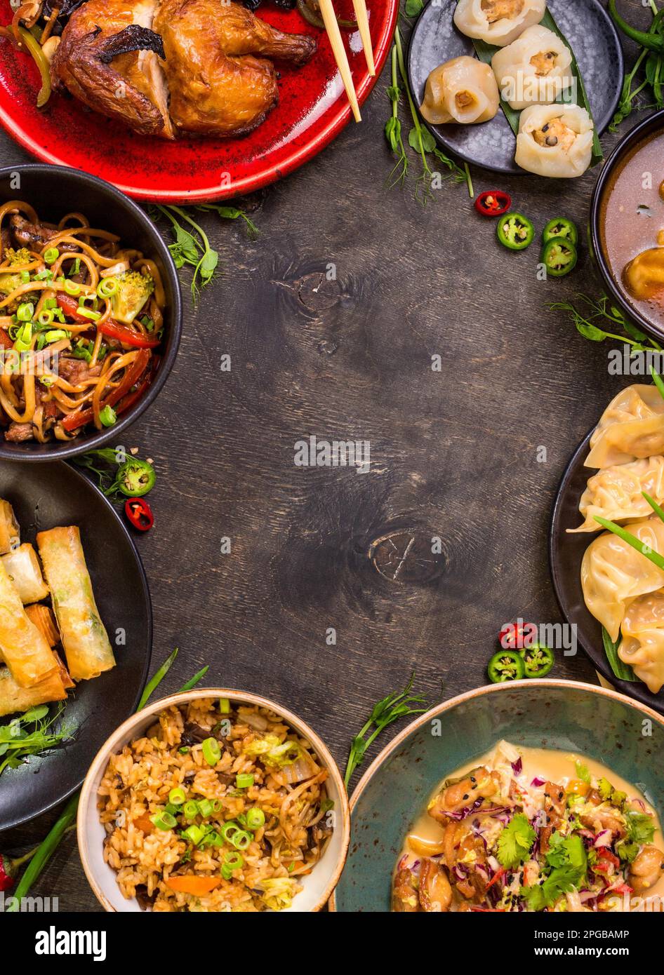 Chinese food dark background. Chinese noodles, fried rice, dumplings ...
