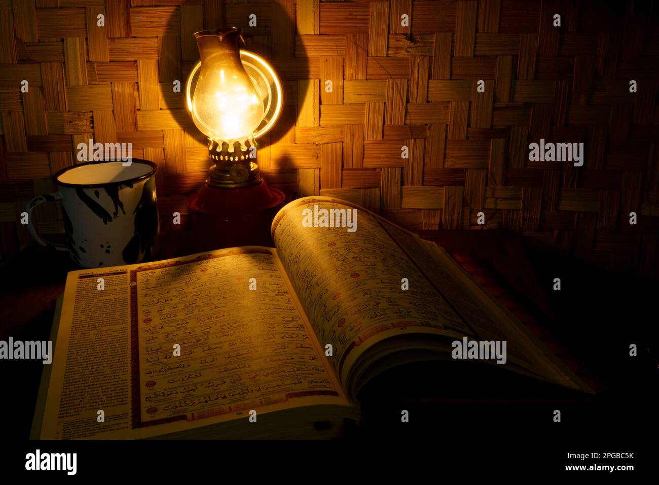 Holy Quran on the wooden table with vintage traditional kerosene lamp ...