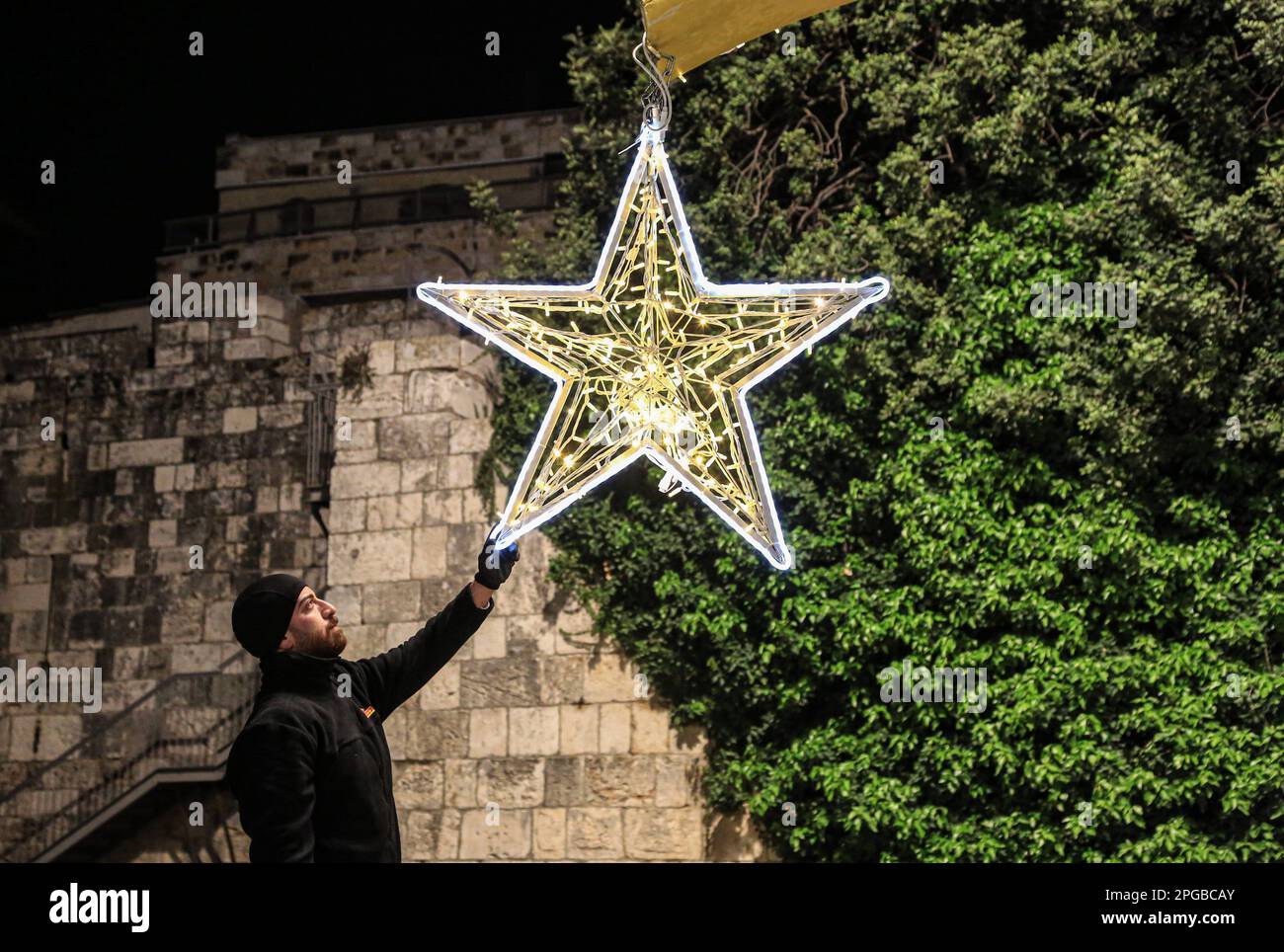 Jerusalem, Israel. 21st Mar, 2023. A man adjusts a star hanging as part ...