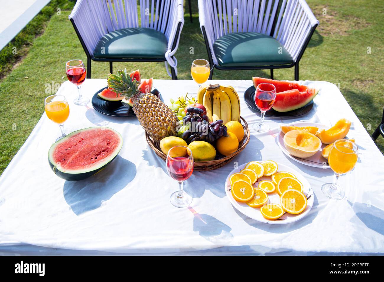 Table full of tropical fresh summer fruits and drinks, glasses full of ...