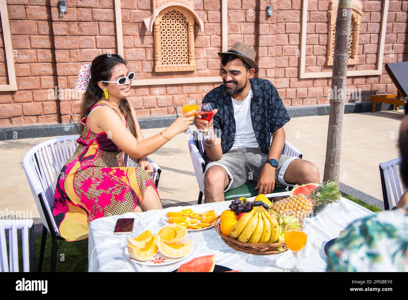 Young Indian Couple Toasting Enjoy Fruits And Juice At Outdoors Summer