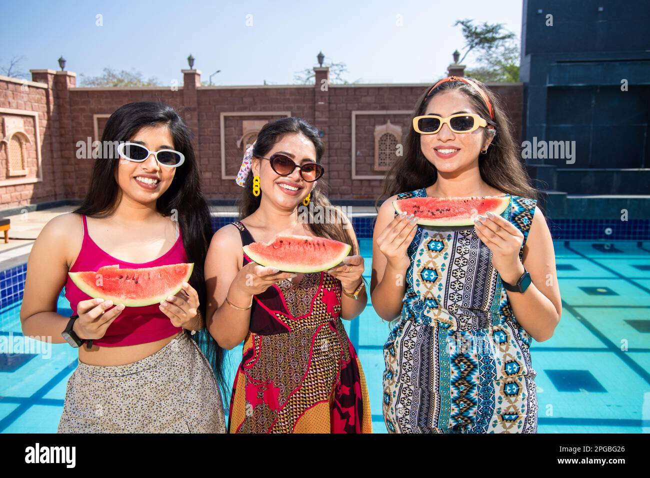Three Beautiful Young Indian Girls Having Fun Together And Eating Watermelon In Hot Summer Day