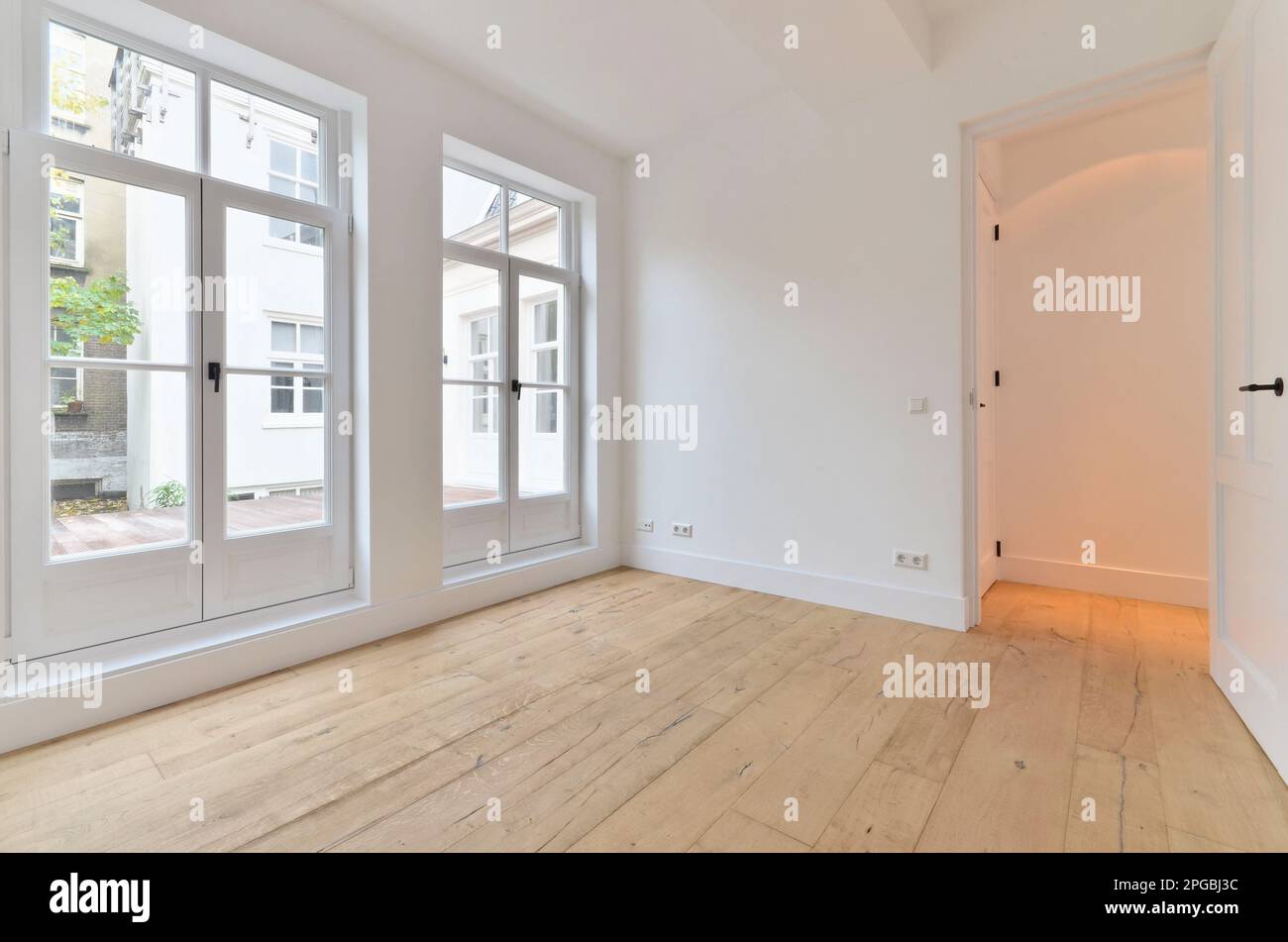 an empty room with white walls and wood flooring, there is a door ...
