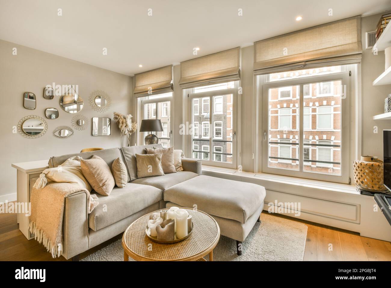 a living room with a couch, coffee table and large window looking out ...