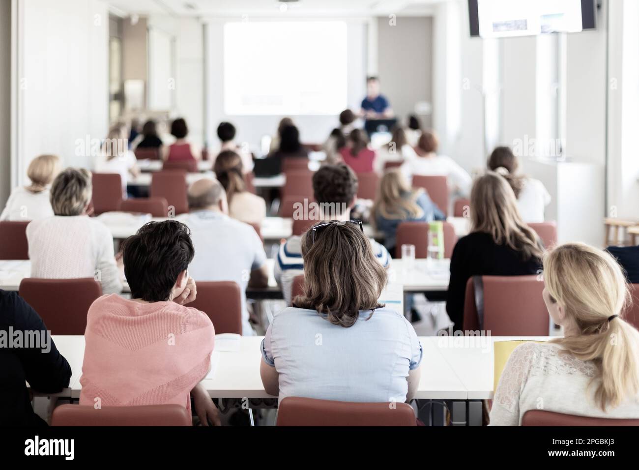 Speaker giving presentation in lecture hall at university. Participants ...