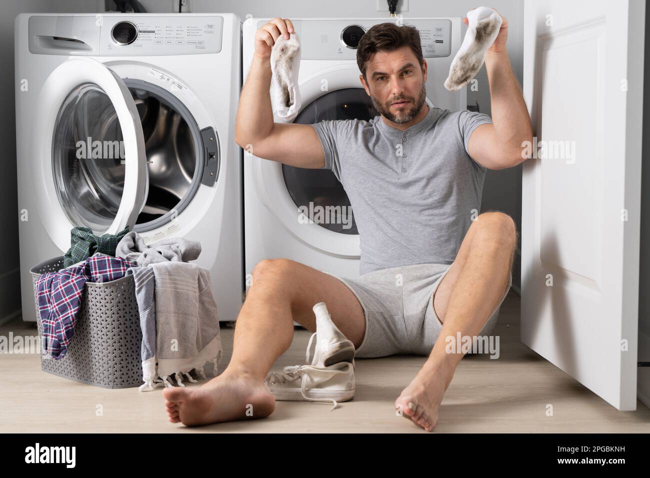 Man with clothes near washing machine. Laundry cleaning. Housework ...