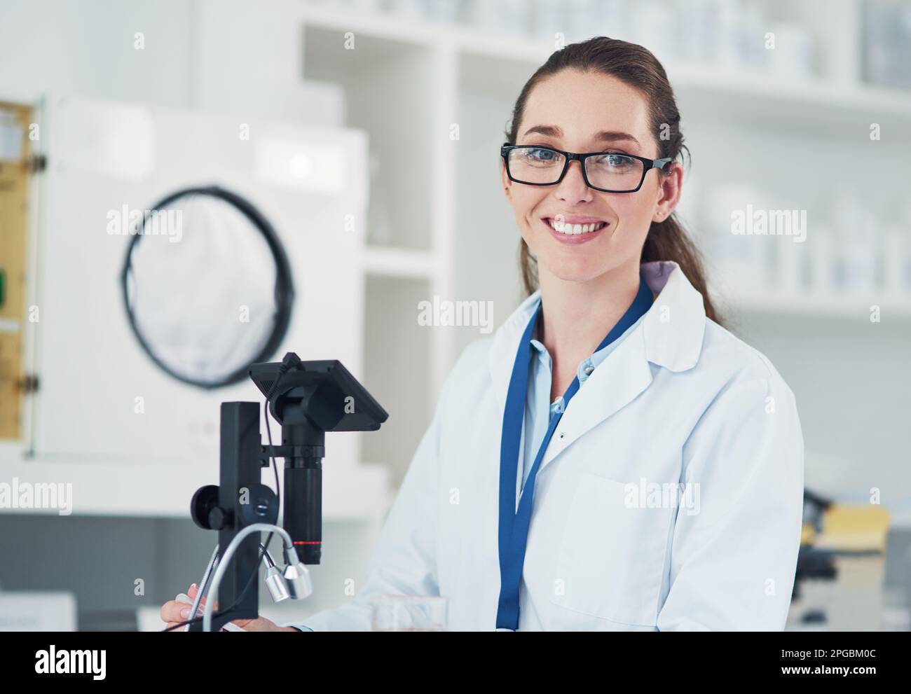 My hard work has payed off. Portrait of a cheerful young female scientist standing at her work ...