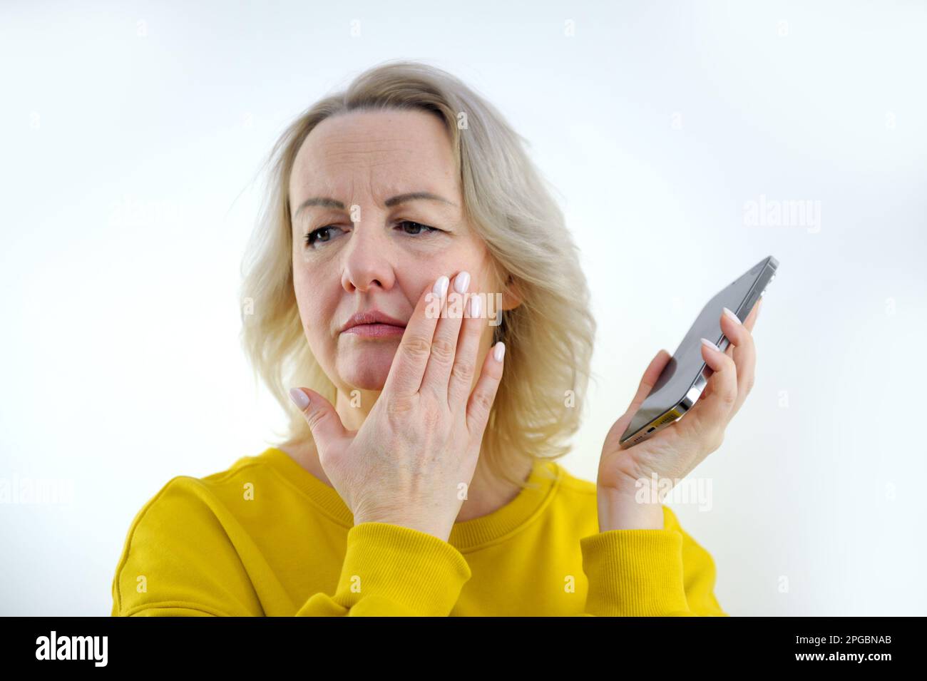 Picture of emotional shocked impressed young model holding smartphone ...