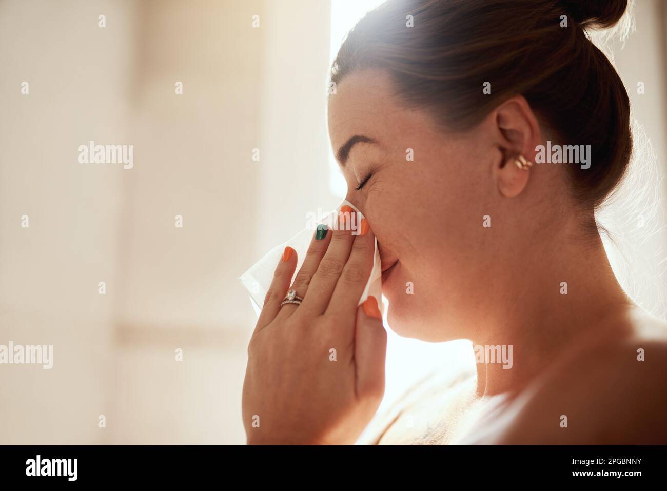 What doesnt belong must go. an attractive young woman blowing her nose ...