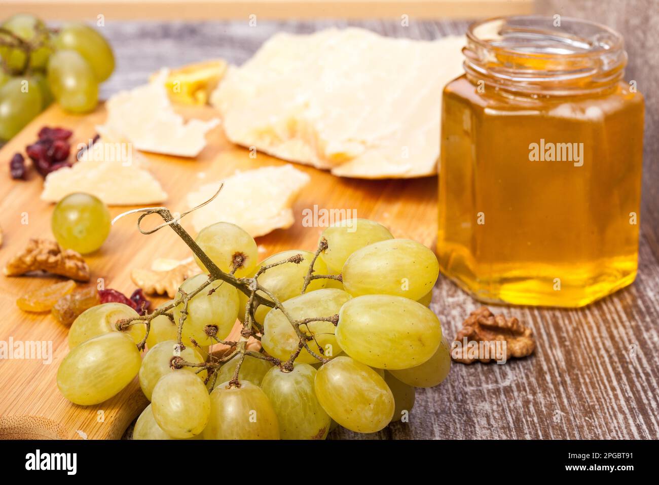 Different type of cheese, honey and grape on wooden background in ...