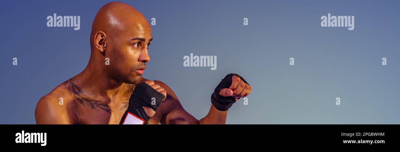 Professional kickboxer is training and practicing punch on studio ...