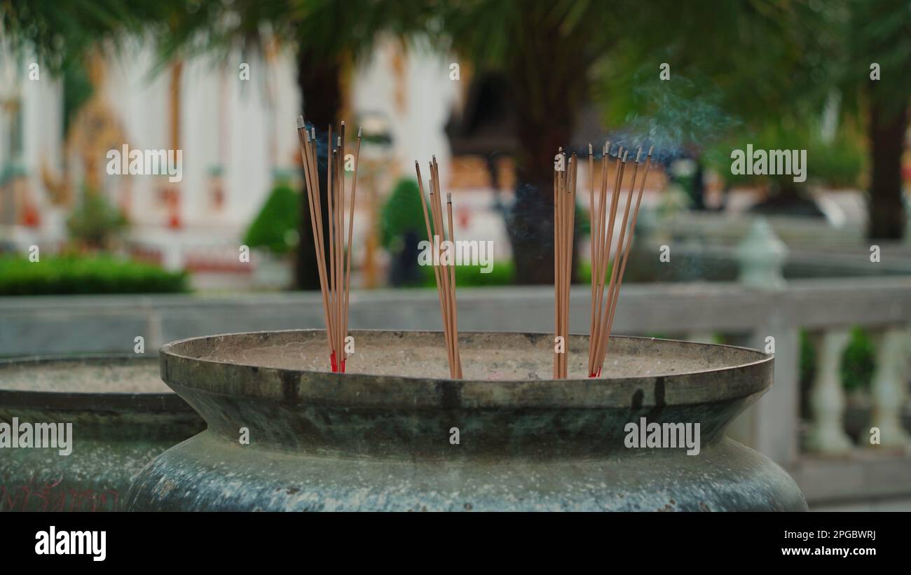 Close-up of a sandalwood incense stick slowly smoldering and releasing ...